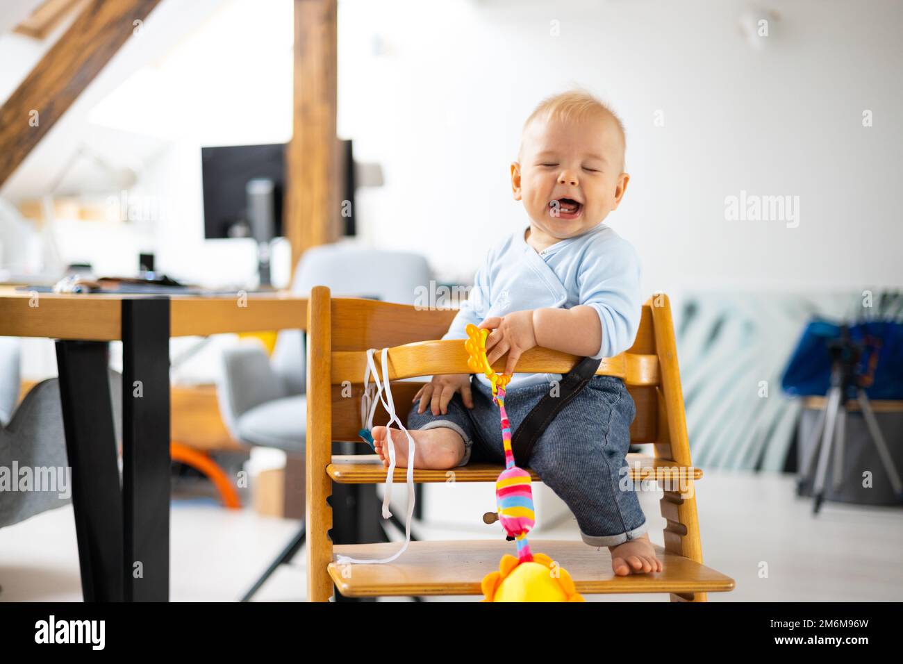 Happy infant sitting and playing with his toy in traditional ...
