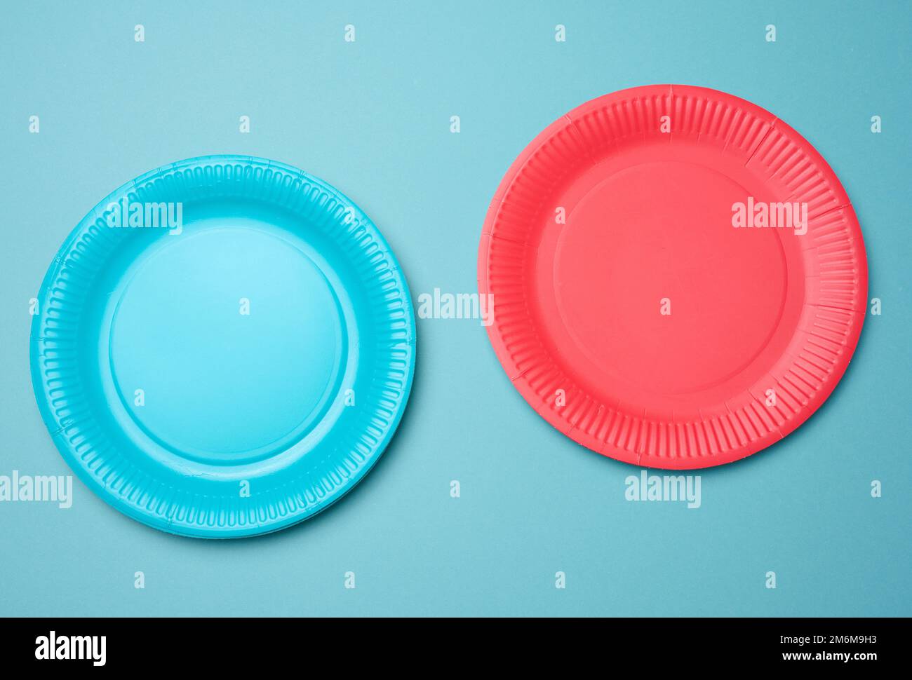 Empty blue, red paper disposable plates on a blue background, top view ...