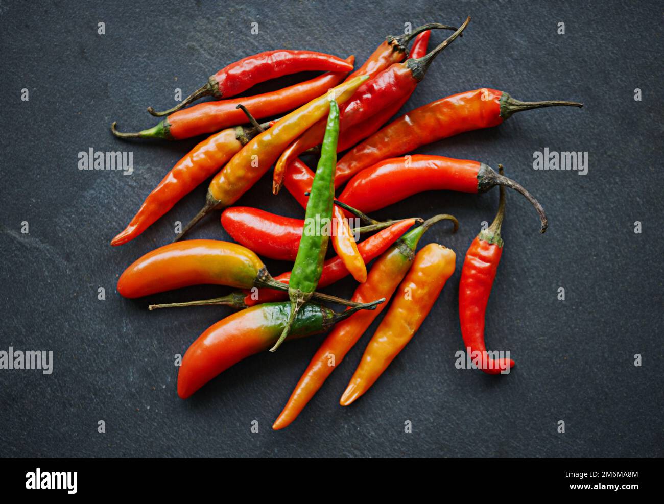 Small but fiery. High angle shot of fresh red chillies on a kitchen ...