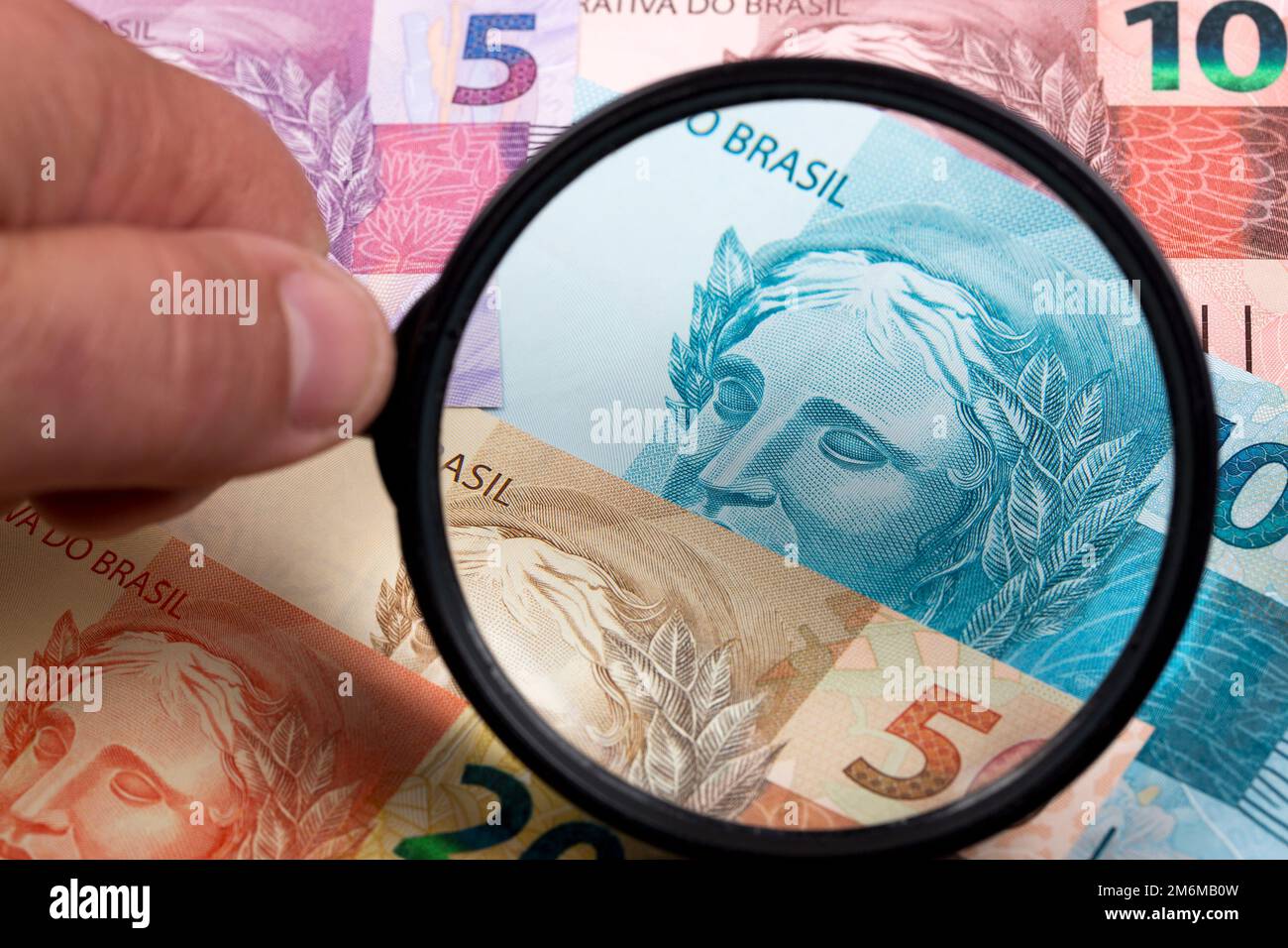 Brazilian money in a magnifying glass a business background Stock Photo ...