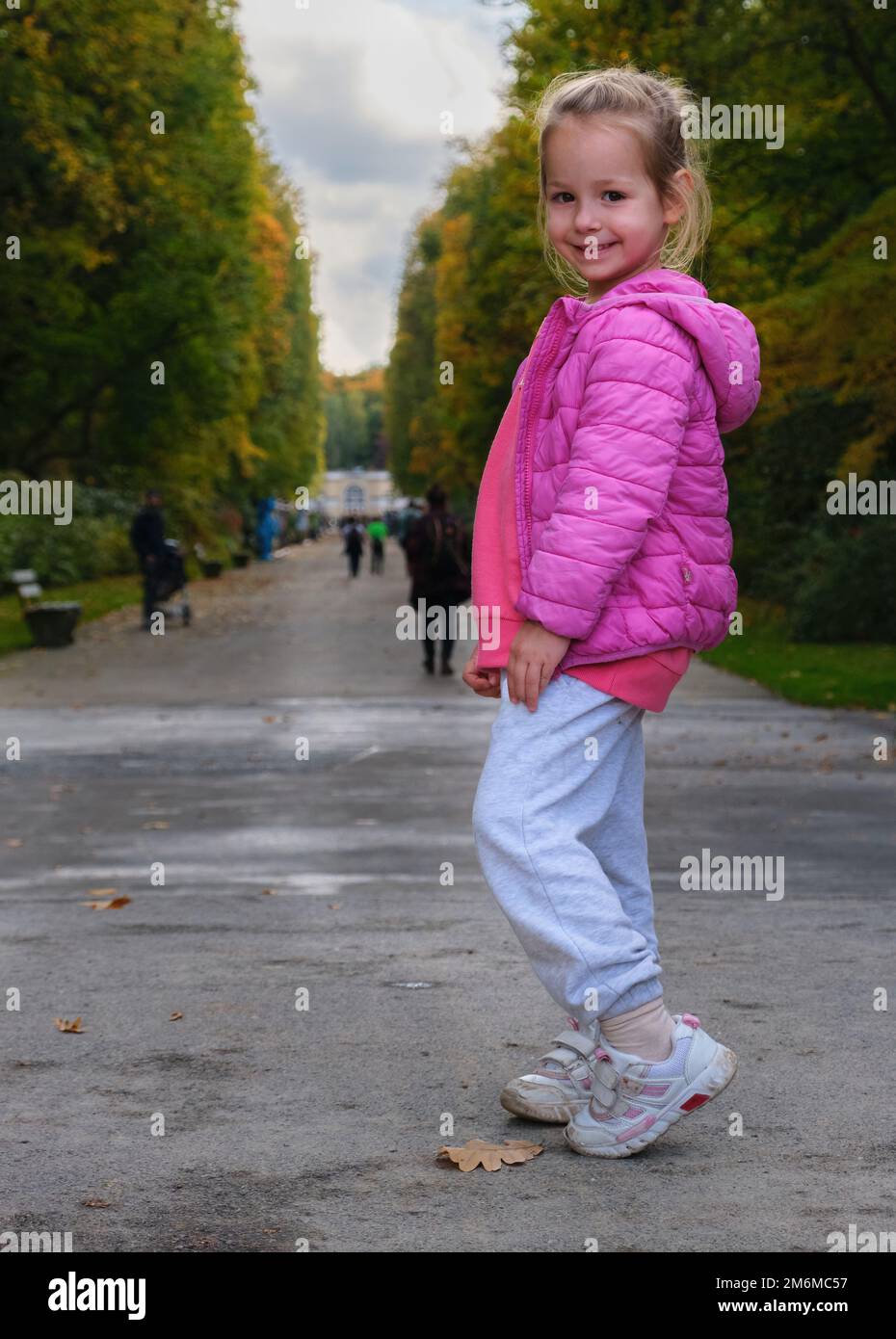 pretty beautiful smiling little girl pink clothes posing city park ...
