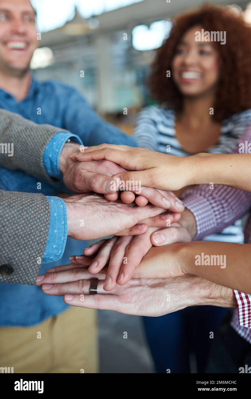 Lets get this done. Closeup shot of co-workers hand put together in an ...