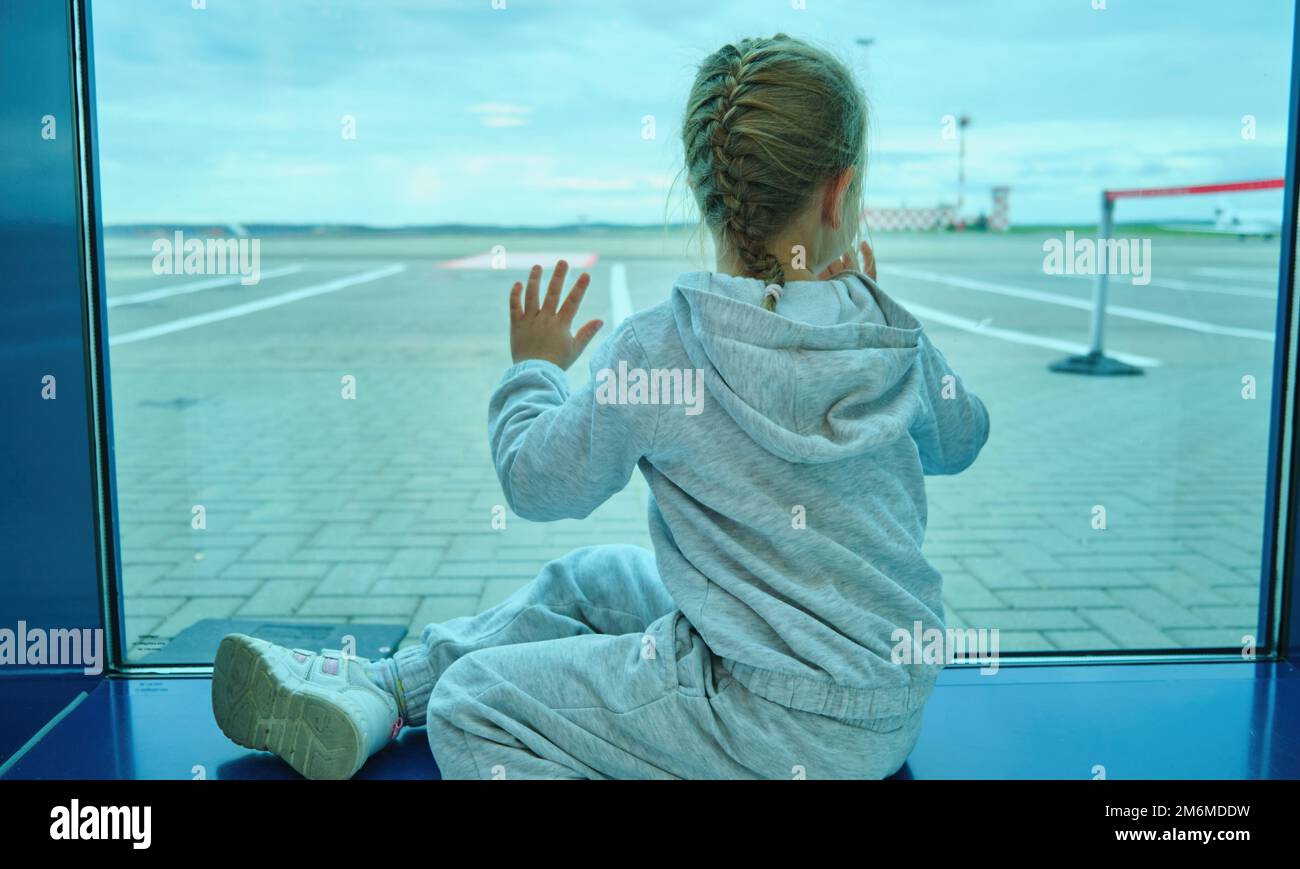 Little girl kid children looking waiting through window to airplane in ...