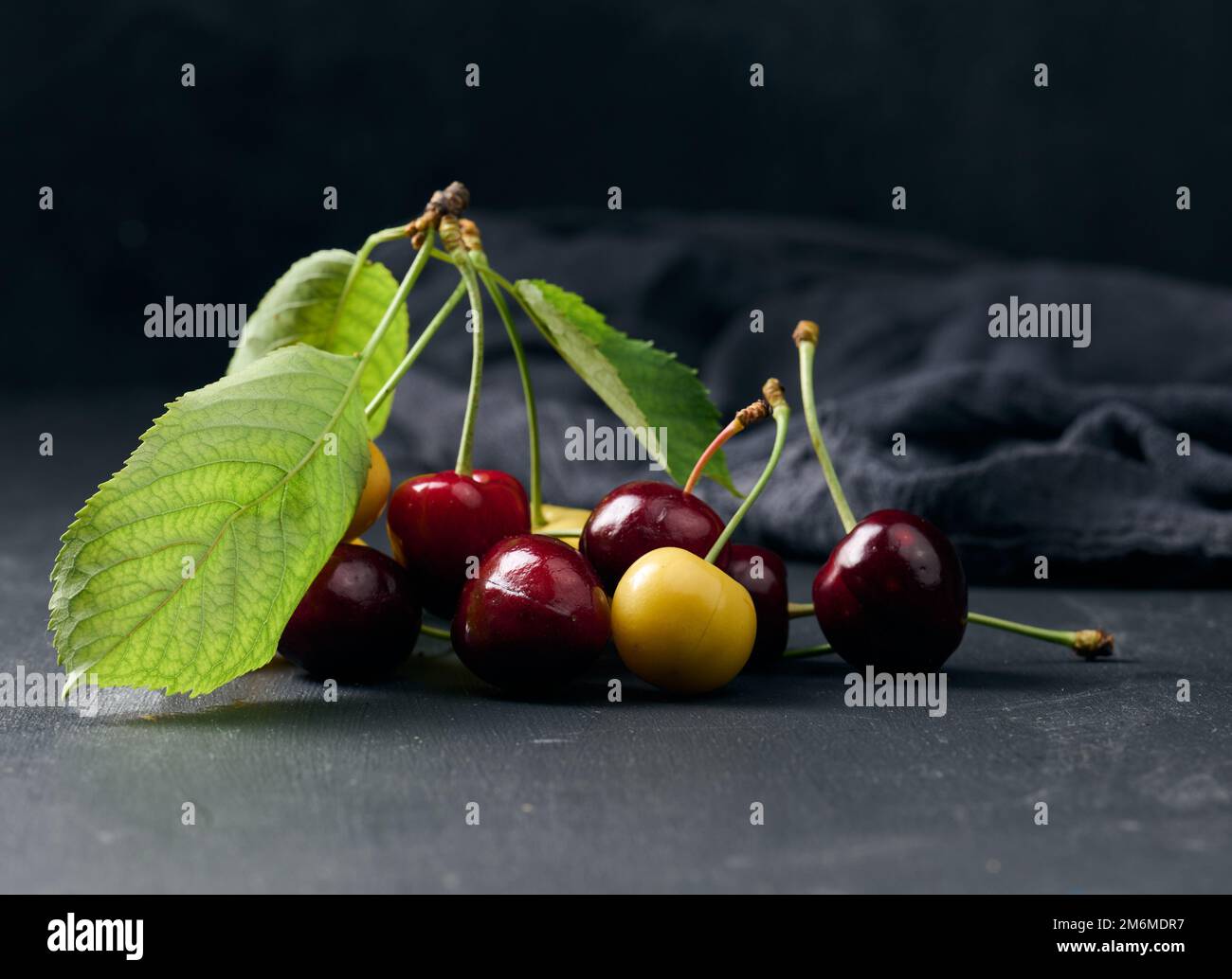 Ripe red and yellow cherries on a black background. summer berry Stock ...