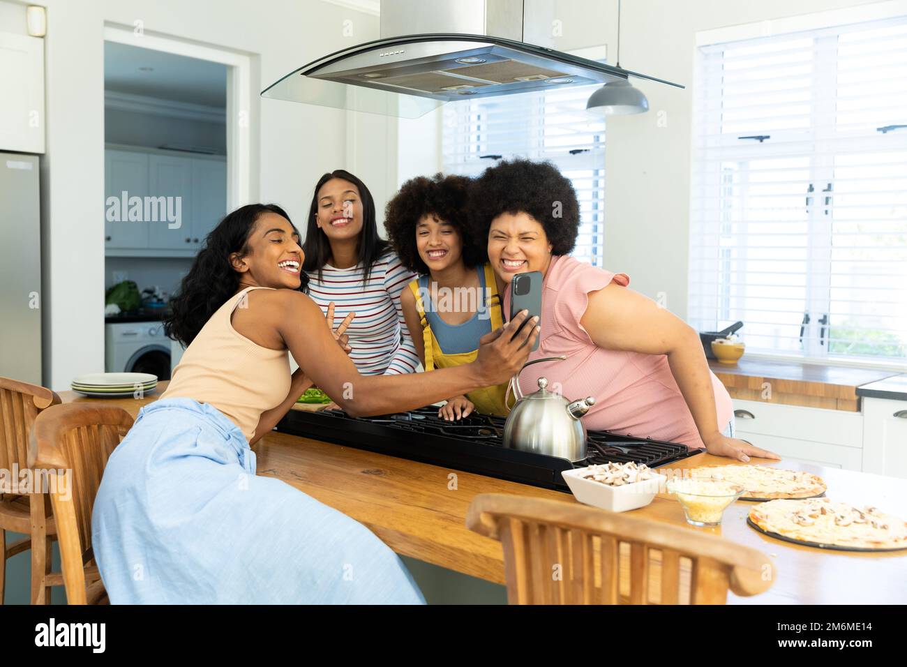 Happy young woman taking selfie with biracial female friends over ...