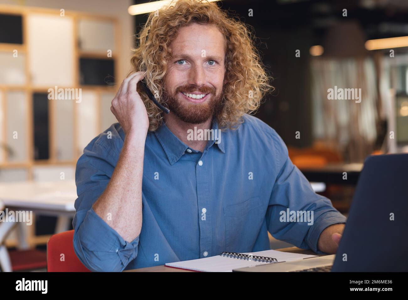 Portrait of smiling young caucasian businessman talking on smart phone ...