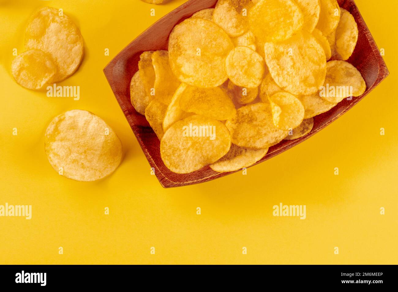 Potato chips or crisps in a bowl, shot from the top on a yellow ...