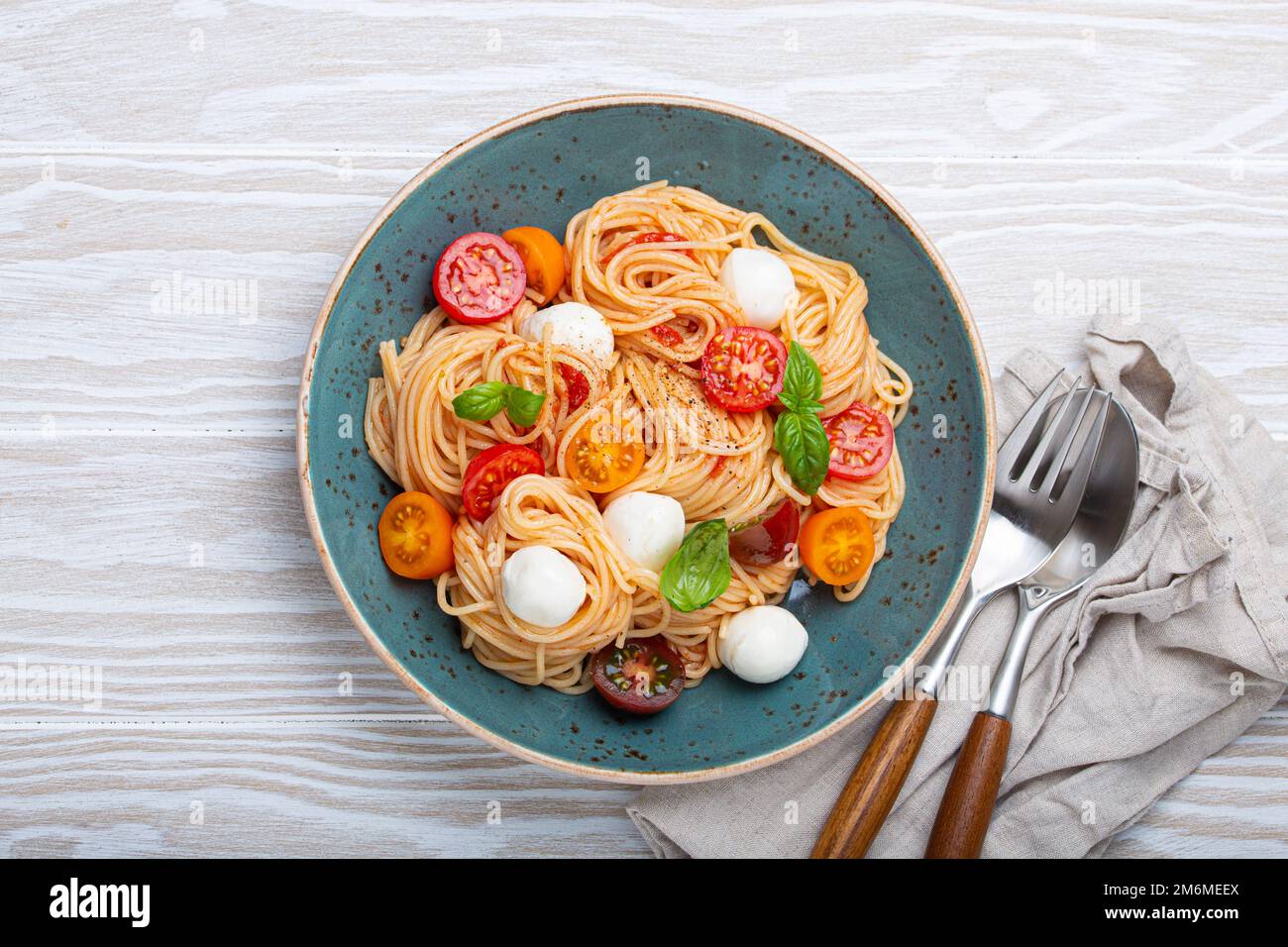 Spaghetti with mozzarella, colourful cherry tomatoes, fresh basil on ...