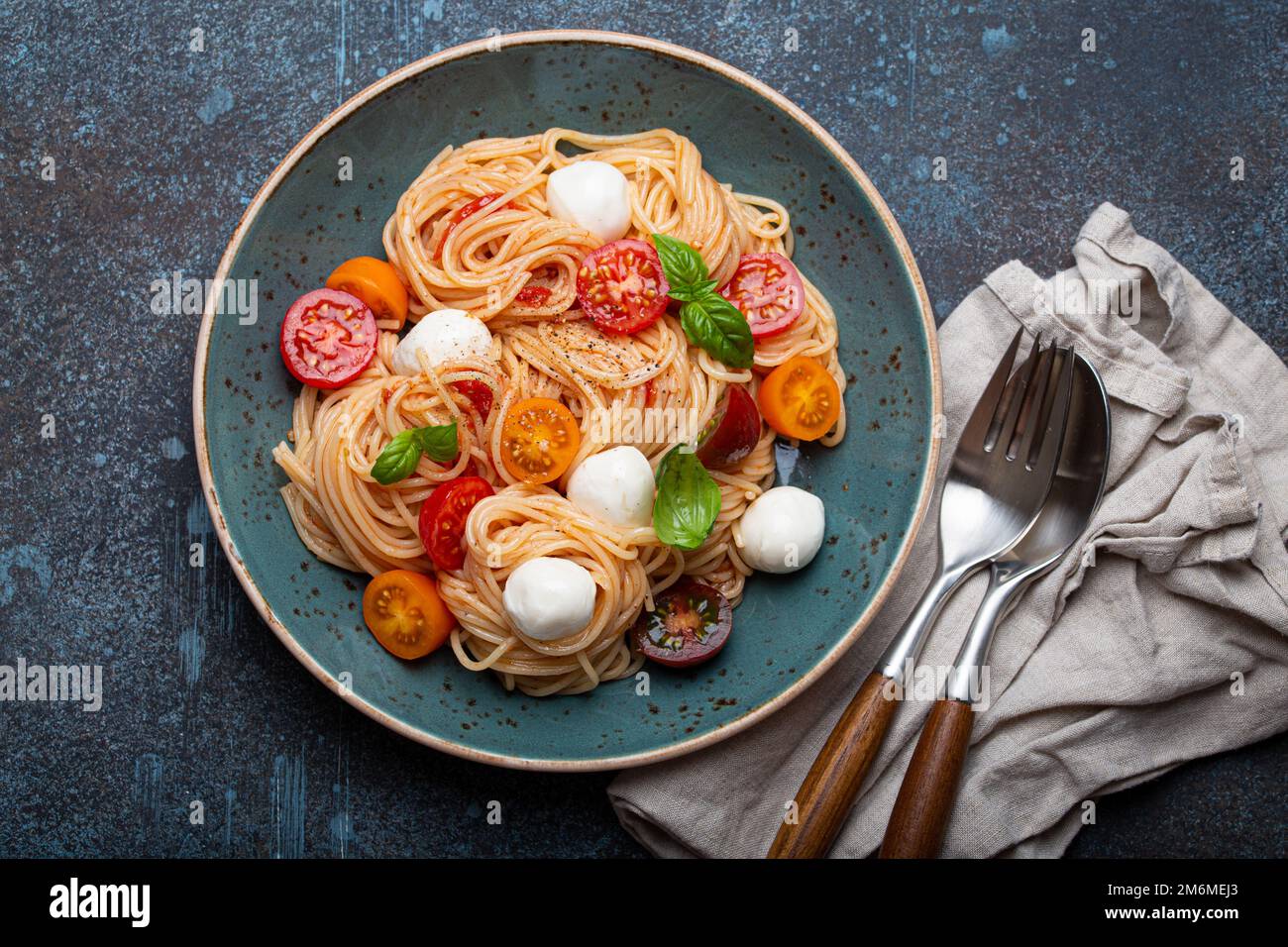 Spaghetti with mozzarella, colourful cherry tomatoes, fresh basil on ...