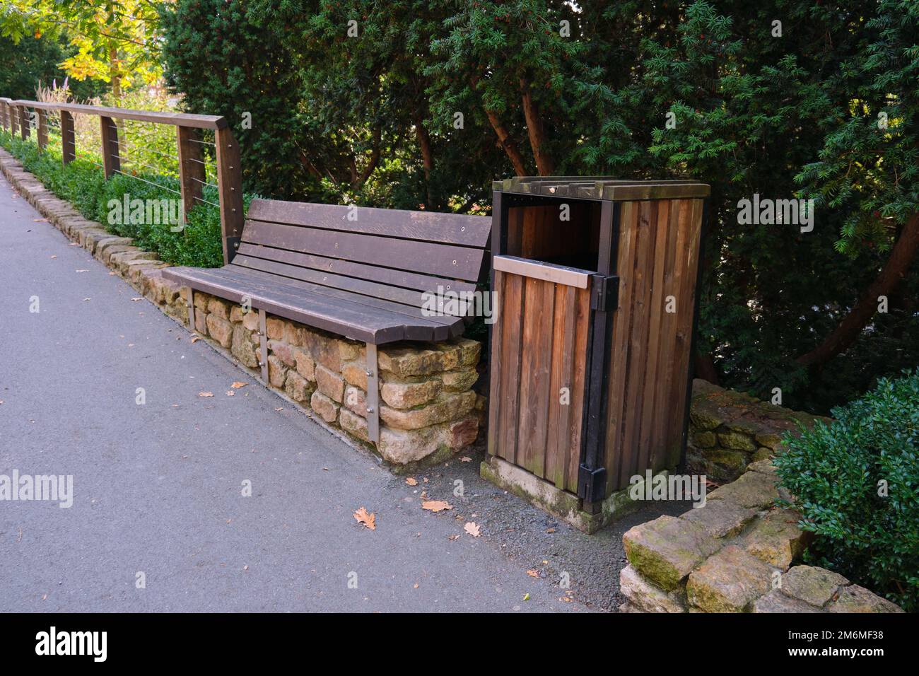 Wooden empty bench next to the trash can in the empty seat summer day ...