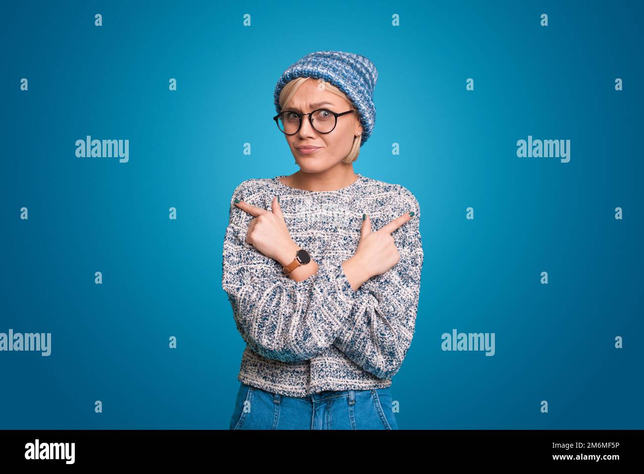 Doubting woman crossing her arms over and pointing to opposite sides ...