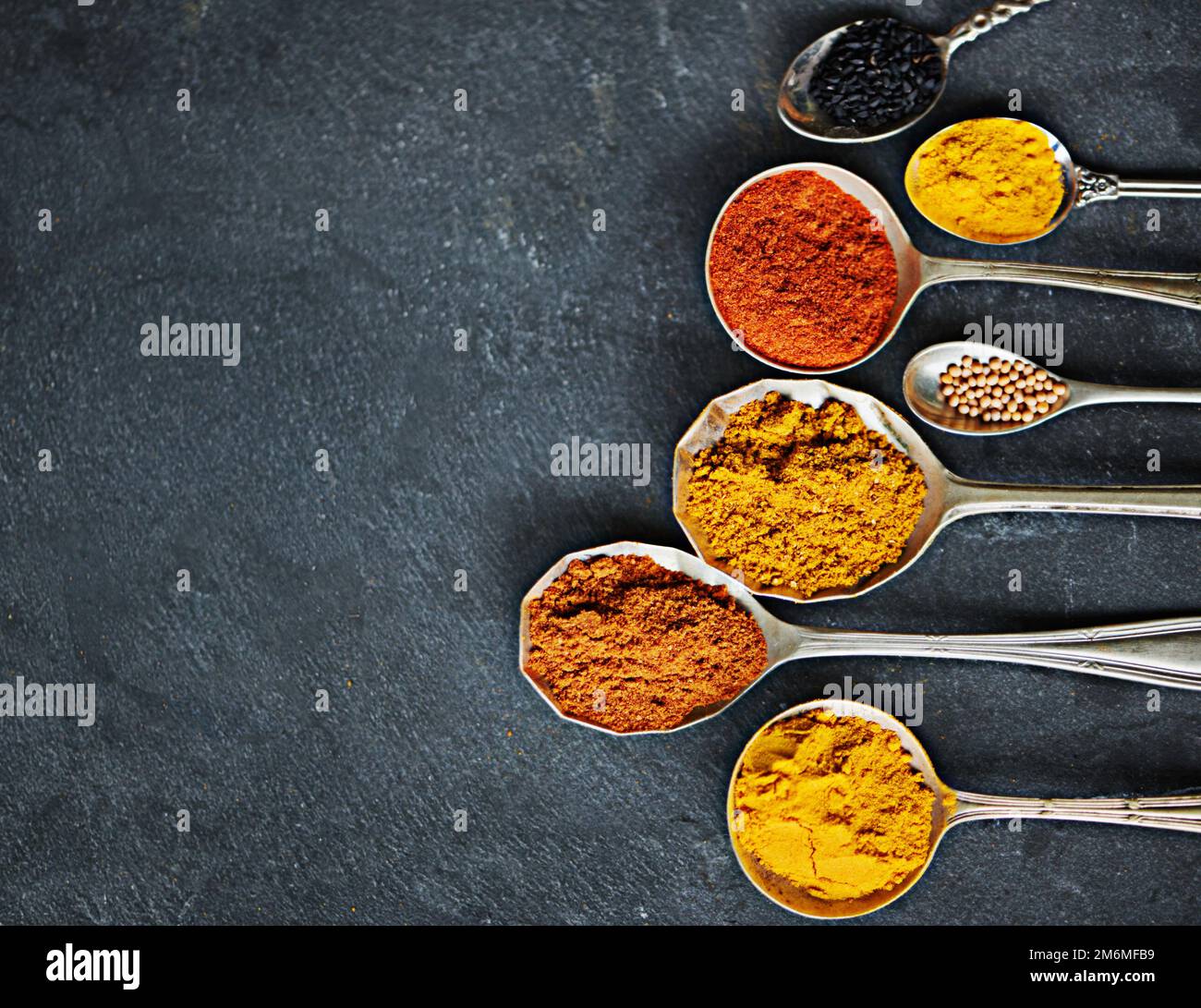 Adding some flavor to your food. spoons filled with a variety of spices ...