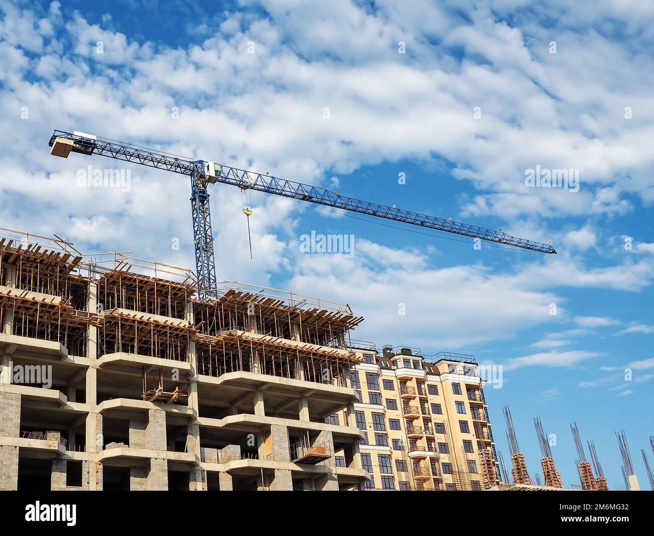 Crane near a house under construction. A crane stands on top of a ...