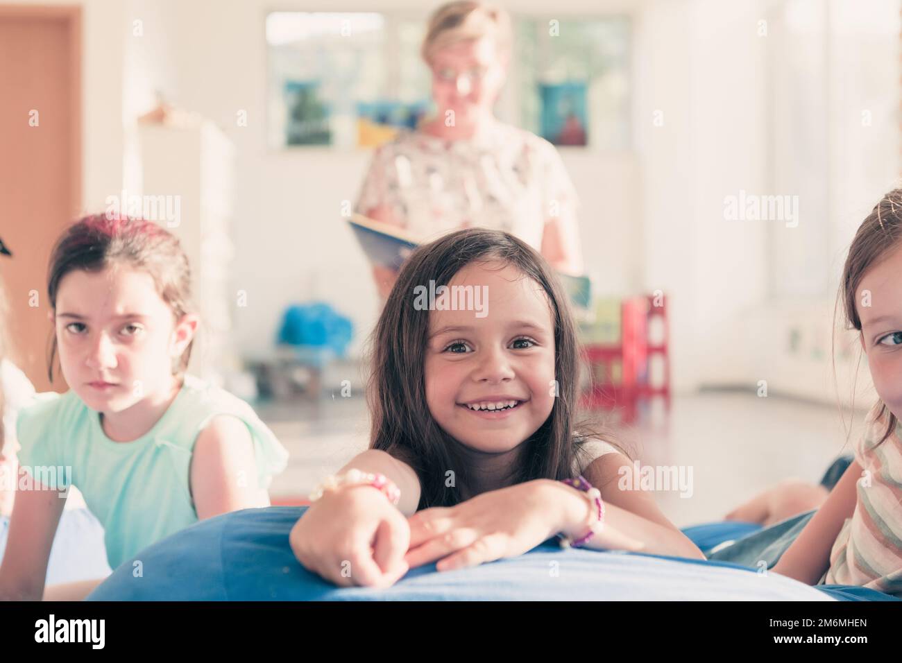 Reading time in elementary school or kindergarten, teacher reading a ...