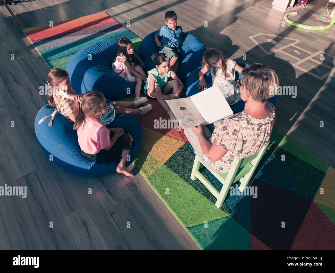 Reading time in elementary school or kindergarten, teacher reading a ...