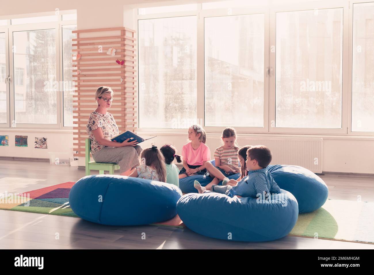 Reading time in elementary school or kindergarten, teacher reading a ...