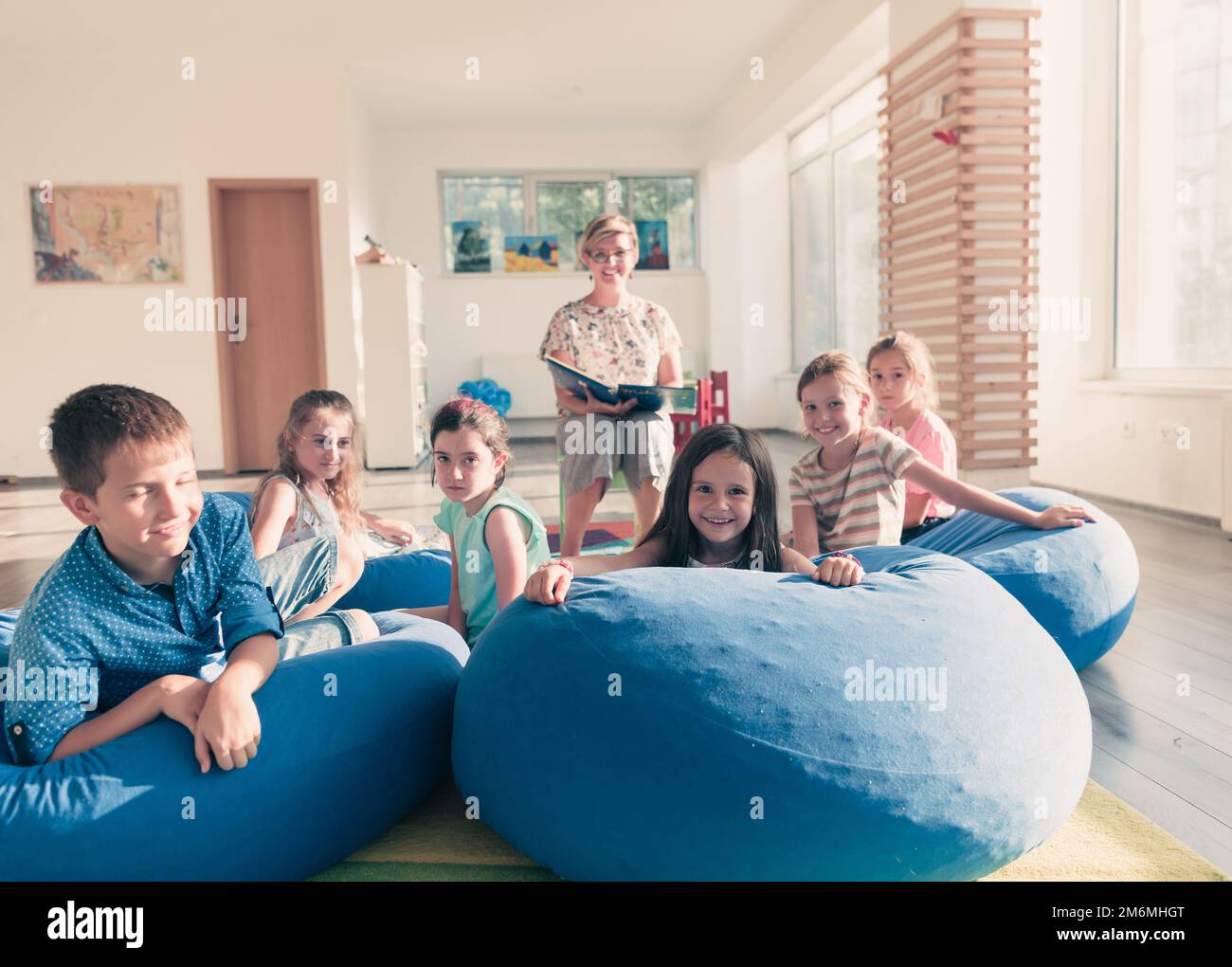 Reading time in elementary school or kindergarten, teacher reading a ...