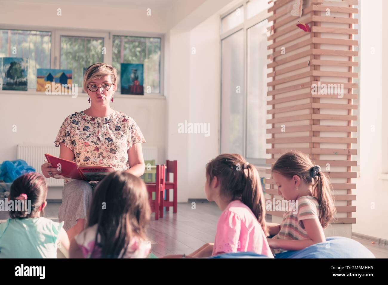 Reading time in elementary school or kindergarten, teacher reading a ...