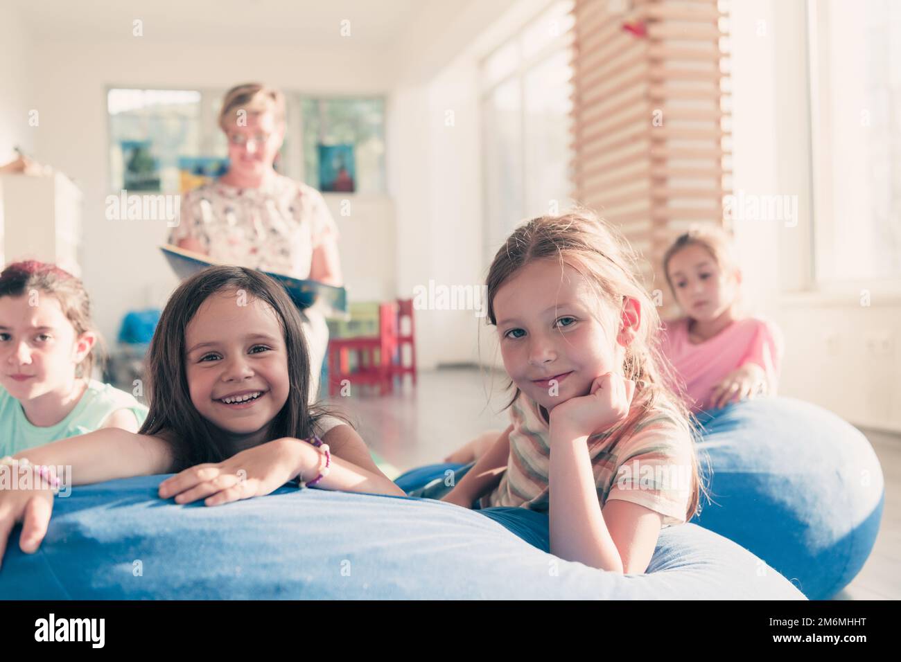 Reading time in elementary school or kindergarten, teacher reading a ...