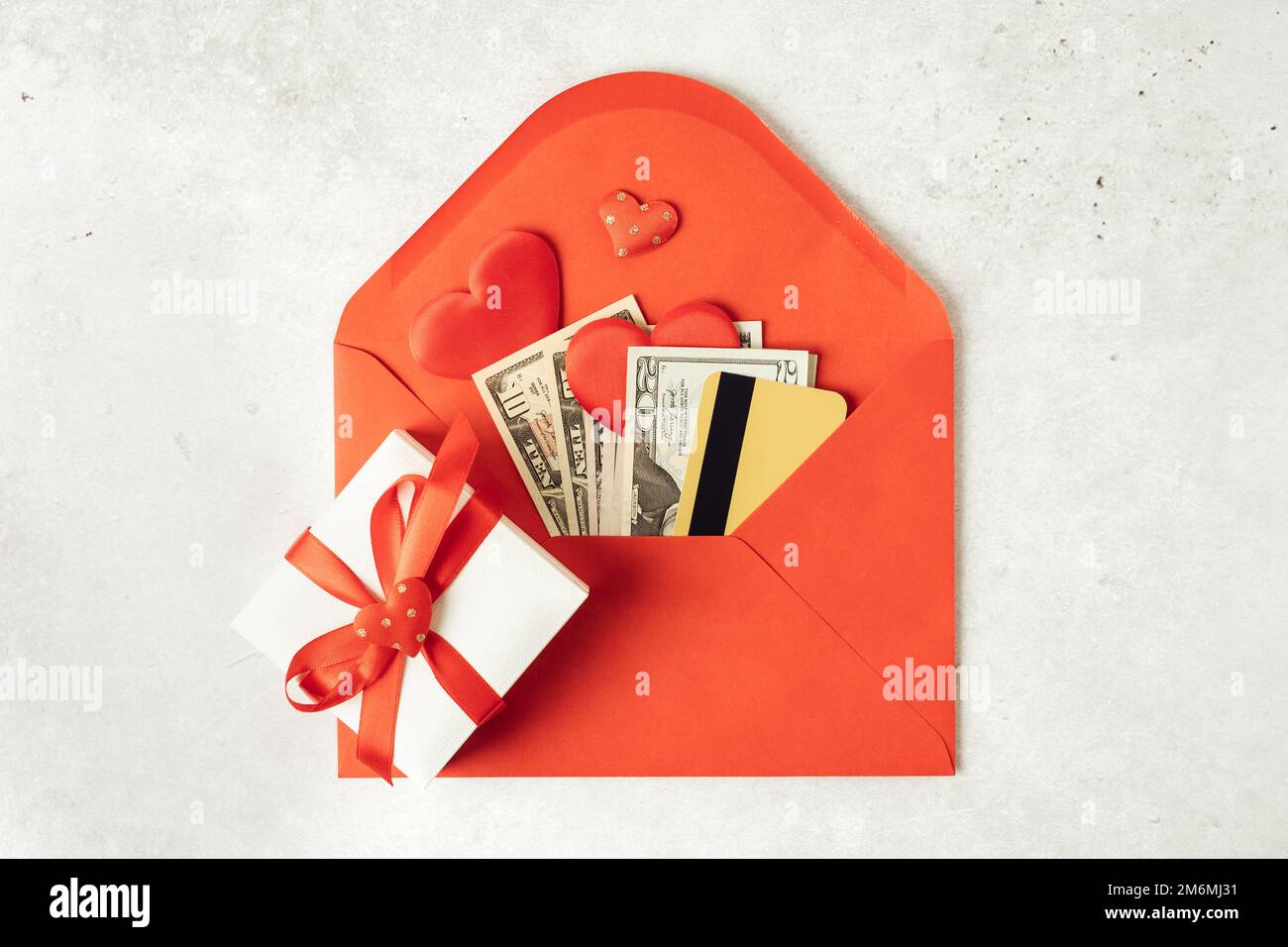 Red paper envelope with money dollars bills and credit card. Flat lay ...