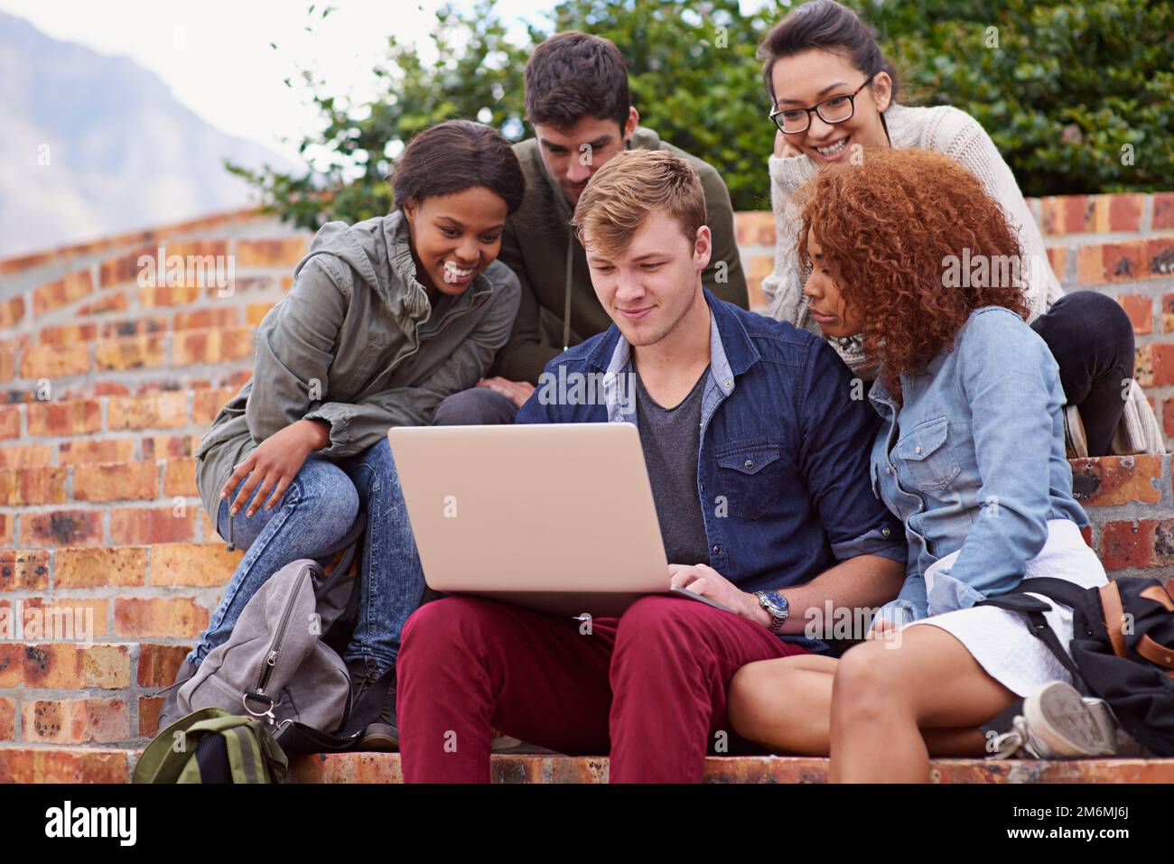 Technology brings everyone together. a group of students sitting ...