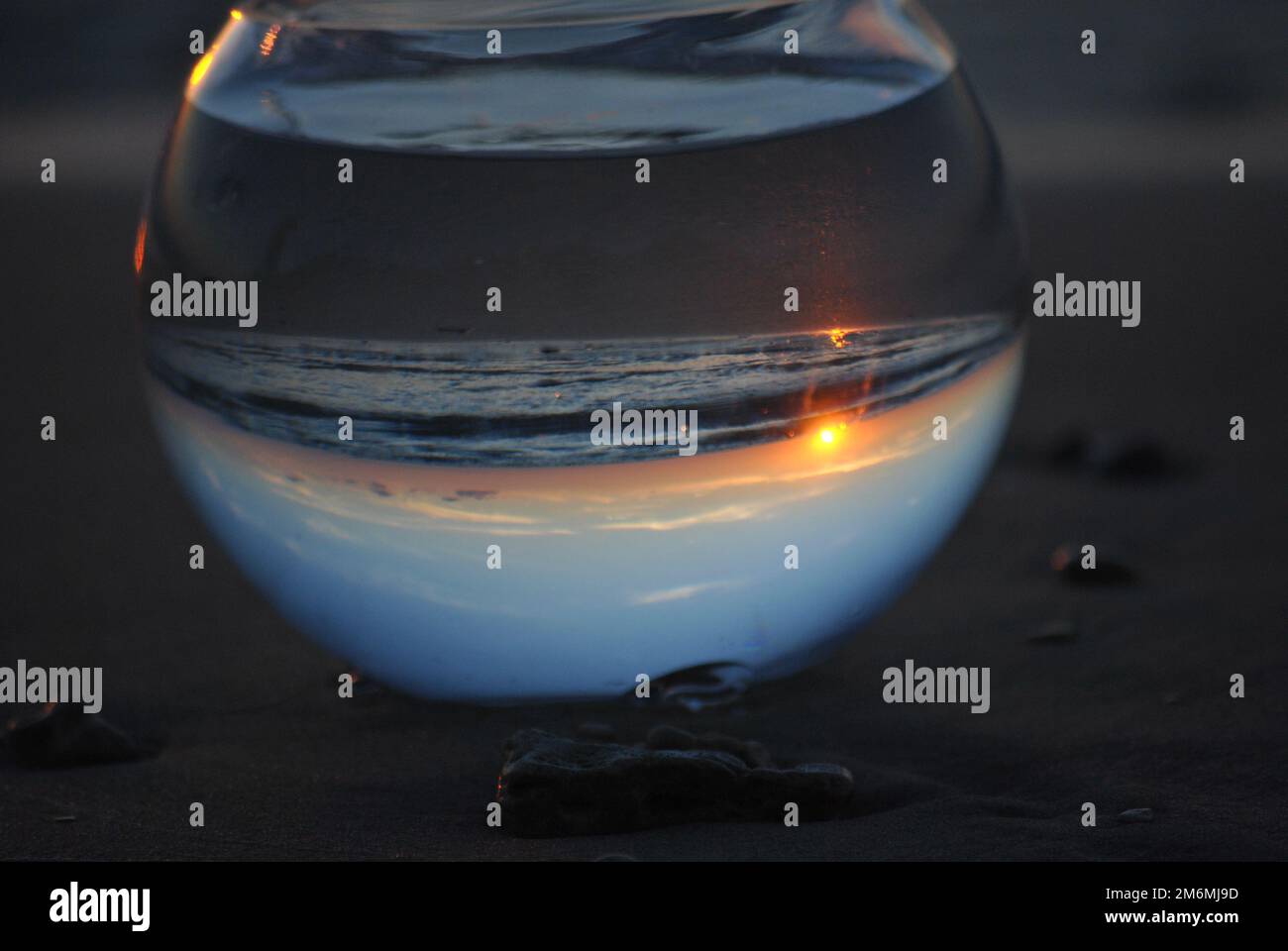 Sea and sundown reflection in a glass bowl on a beach Stock Photo - Alamy