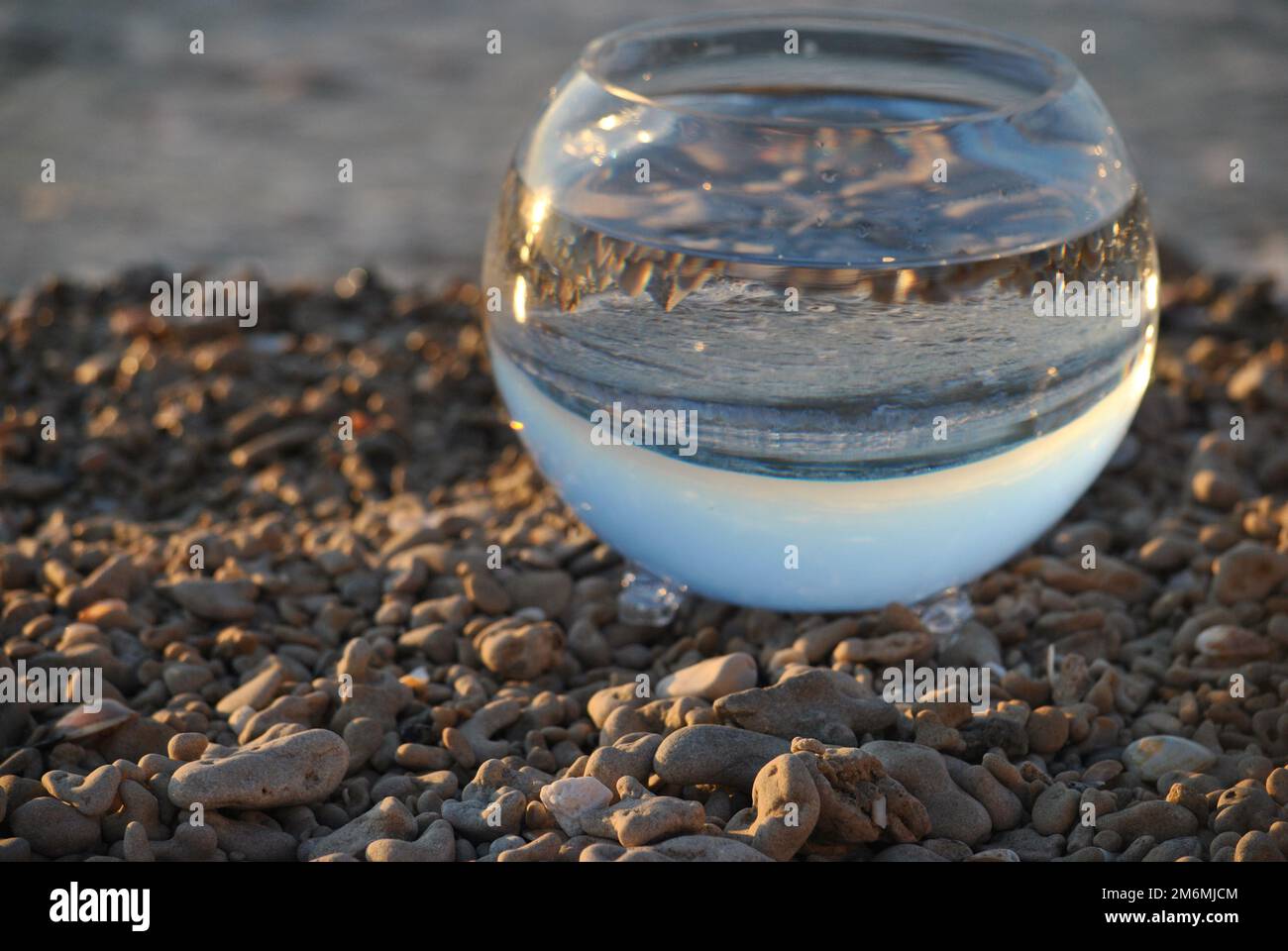 Sea and sundown reflection in a glass bowl on a beach Stock Photo - Alamy