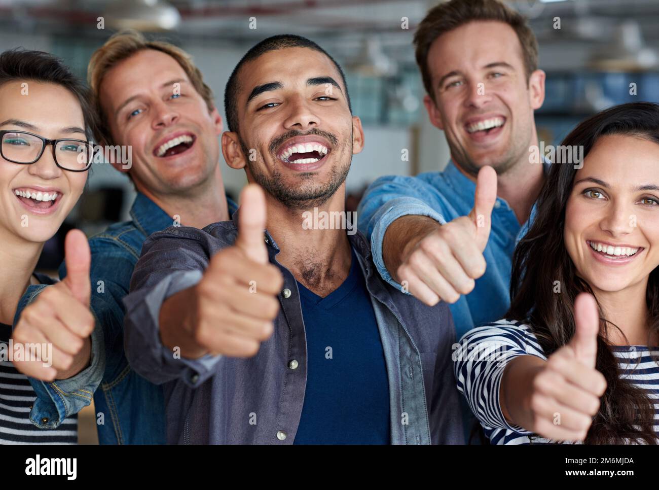 Heres to us. Positive group of creative professionals smiling and ...