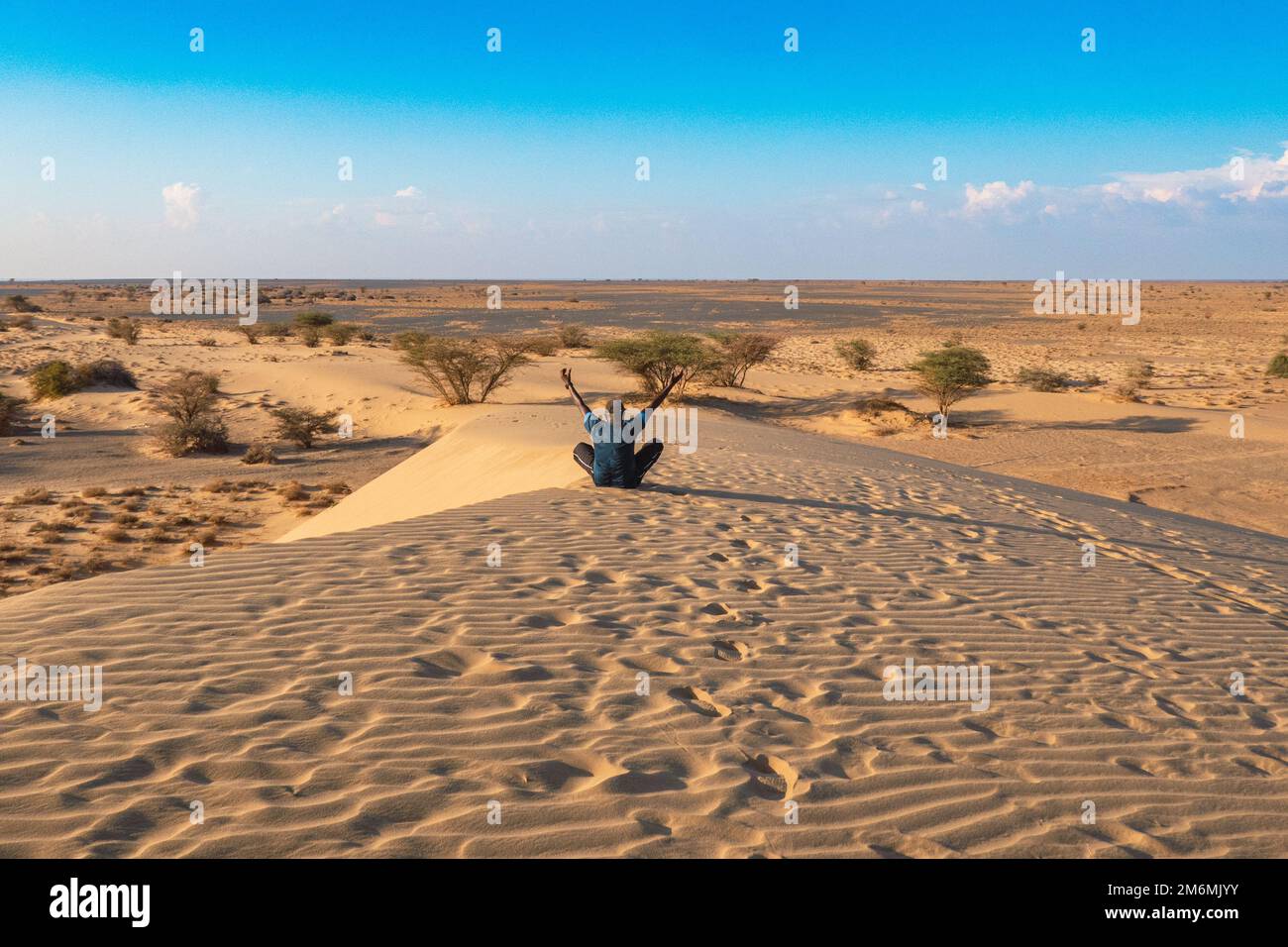 A tourist doing a yoga pose on a beautiful sand dune at North Horr Sand ...