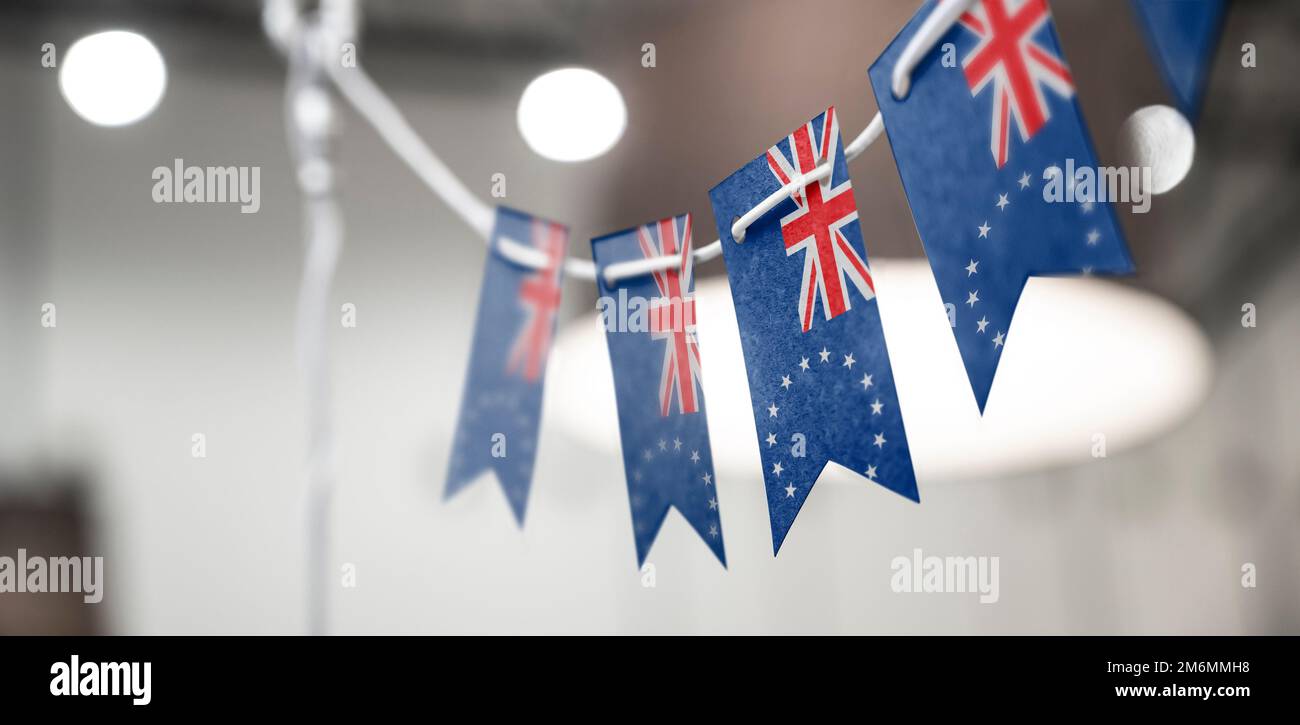 A garland of Cook Islands national flags on an abstract blurred ...
