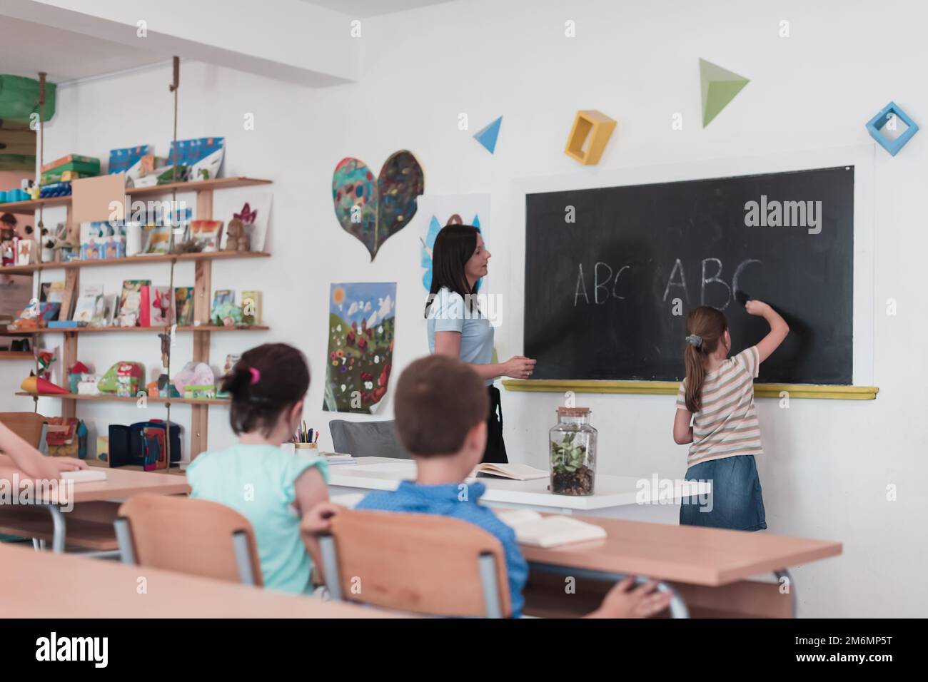 Elementary school. The female teacher helping the child student while ...