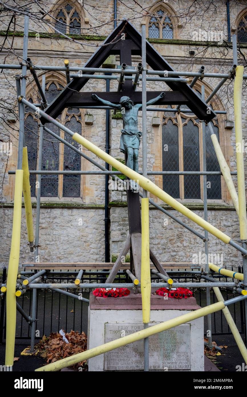 Construction scaffolding surrounds a war memorial crucifix outside a ...