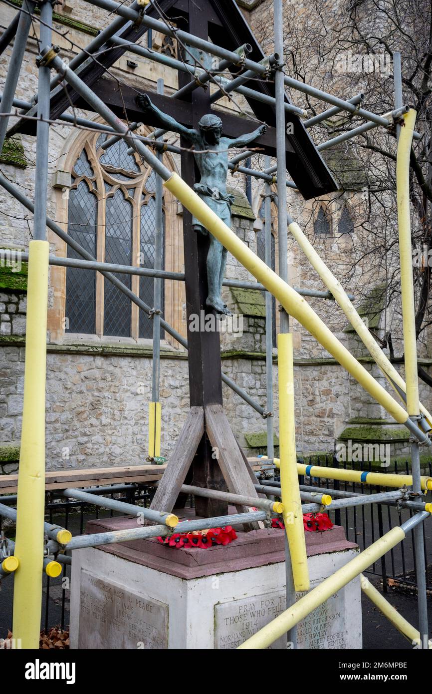 Construction scaffolding surrounds a war memorial crucifix outside a ...