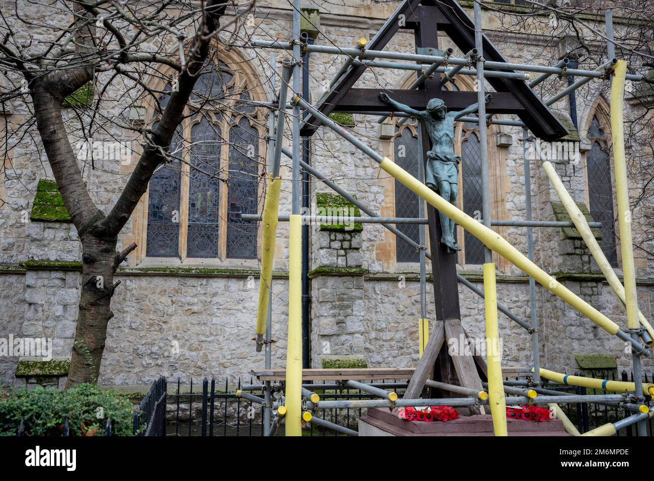 Construction scaffolding surrounds a war memorial crucifix outside a ...