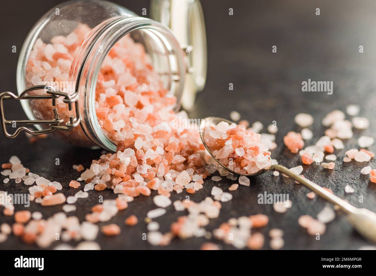 Pink himalayan salt in jar on the black table Stock Photo - Alamy