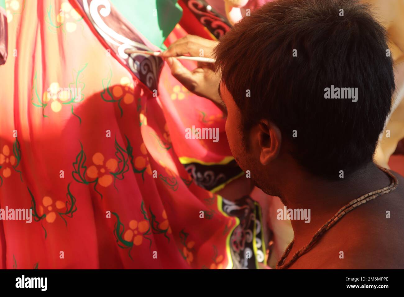 An artist hand-painting a Durga (sculpture) in vibrant hues, capturing ...