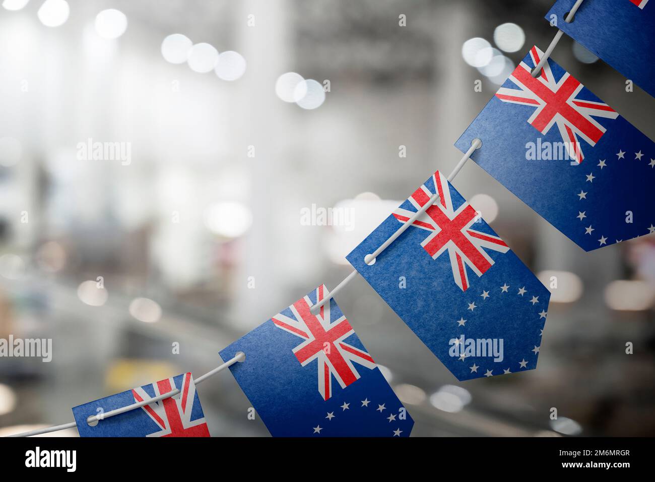 A garland of Cook Islands national flags on an abstract blurred ...