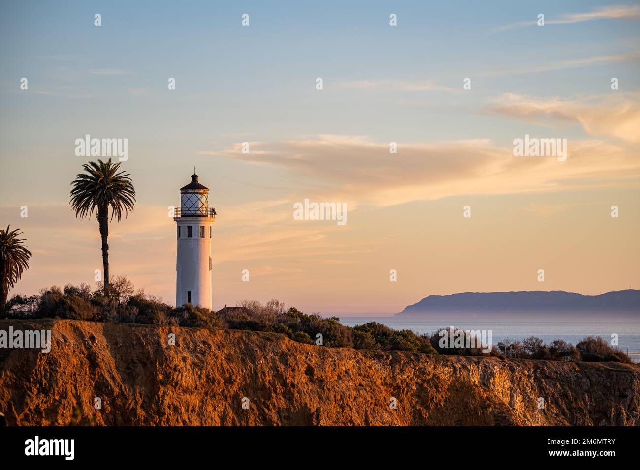 A lighthouse on the shore at sunset Stock Photo - Alamy