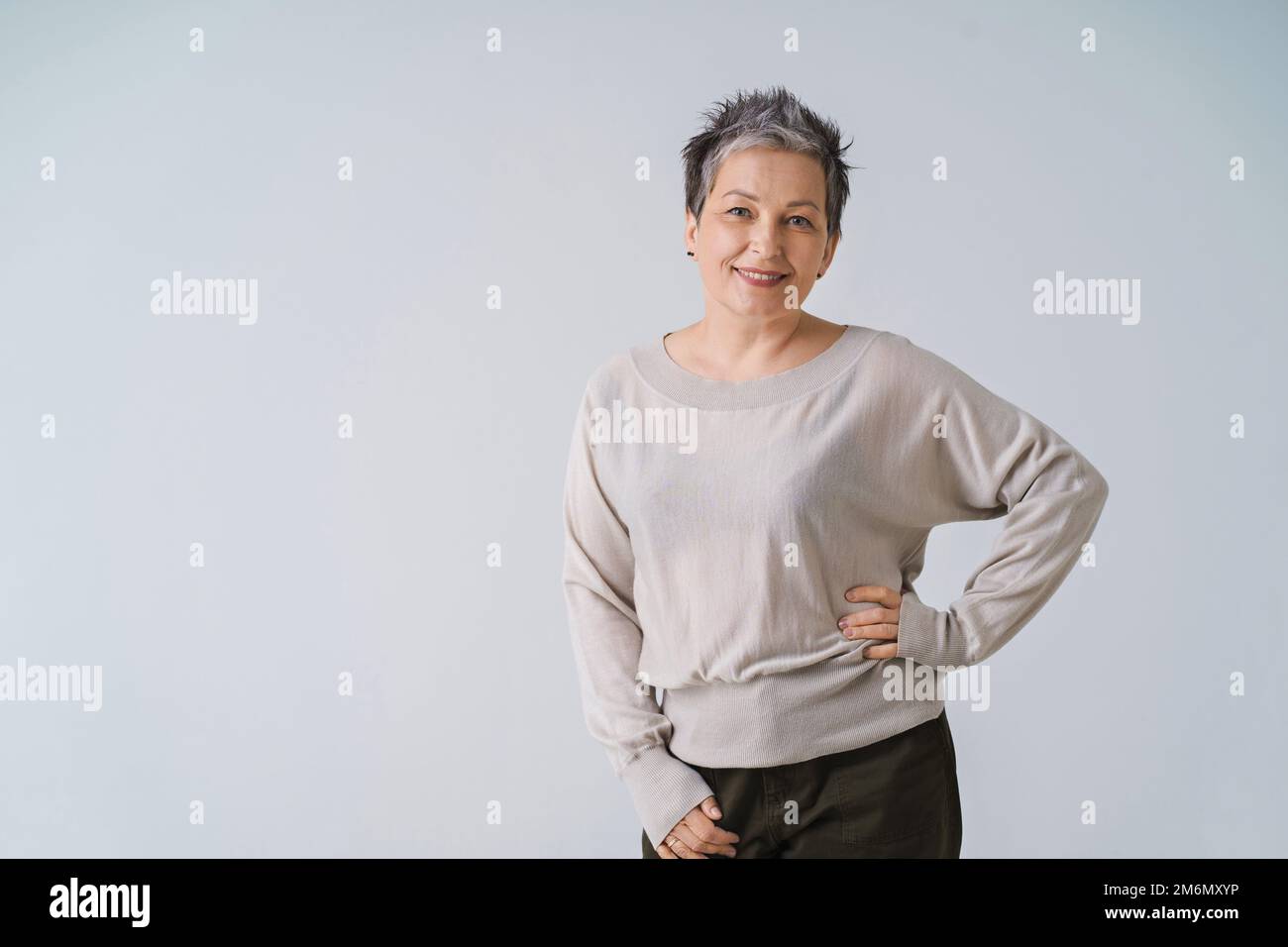Happy smiling grey hair mature woman 50s posing shoulders slightly up ...