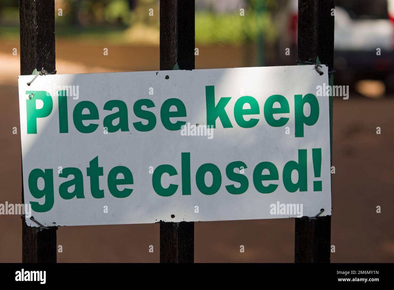 Green letters on white background with words please keep gate closed ...