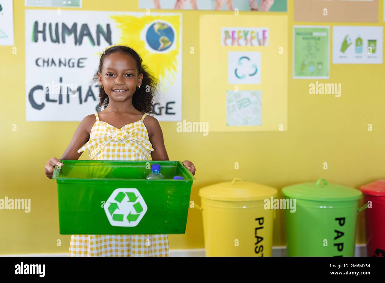 Portrait of smiling african american elementary schoolgirl holding ...