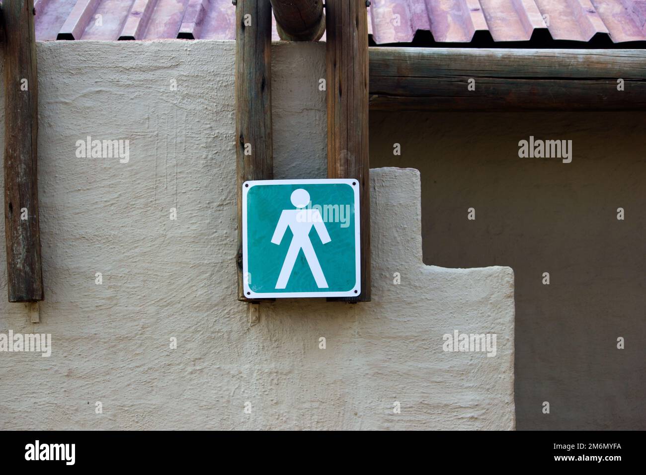 Green and white metalic square information sign nailed to wall to show ...
