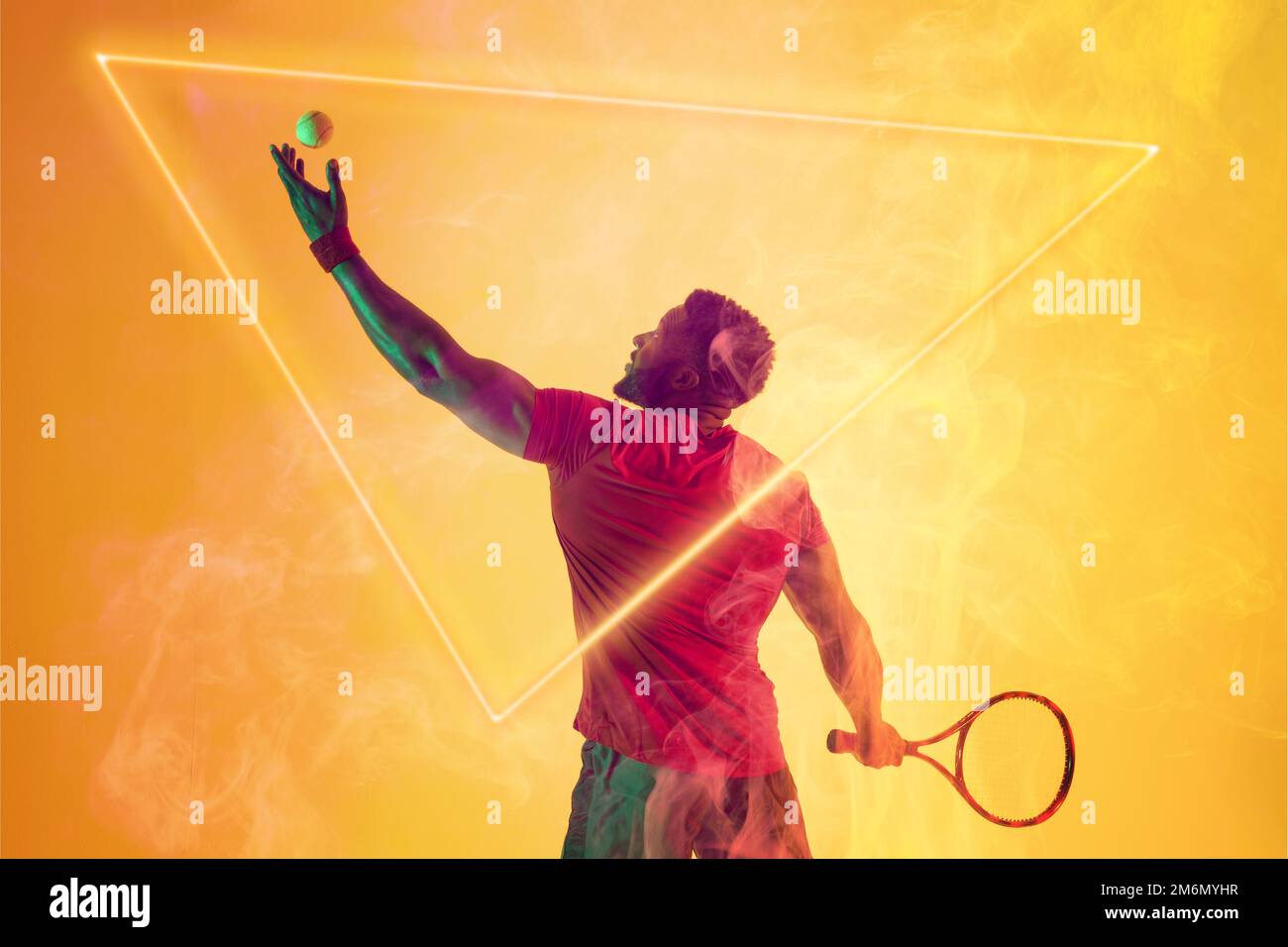 African american male tennis player serving ball with racket by ...