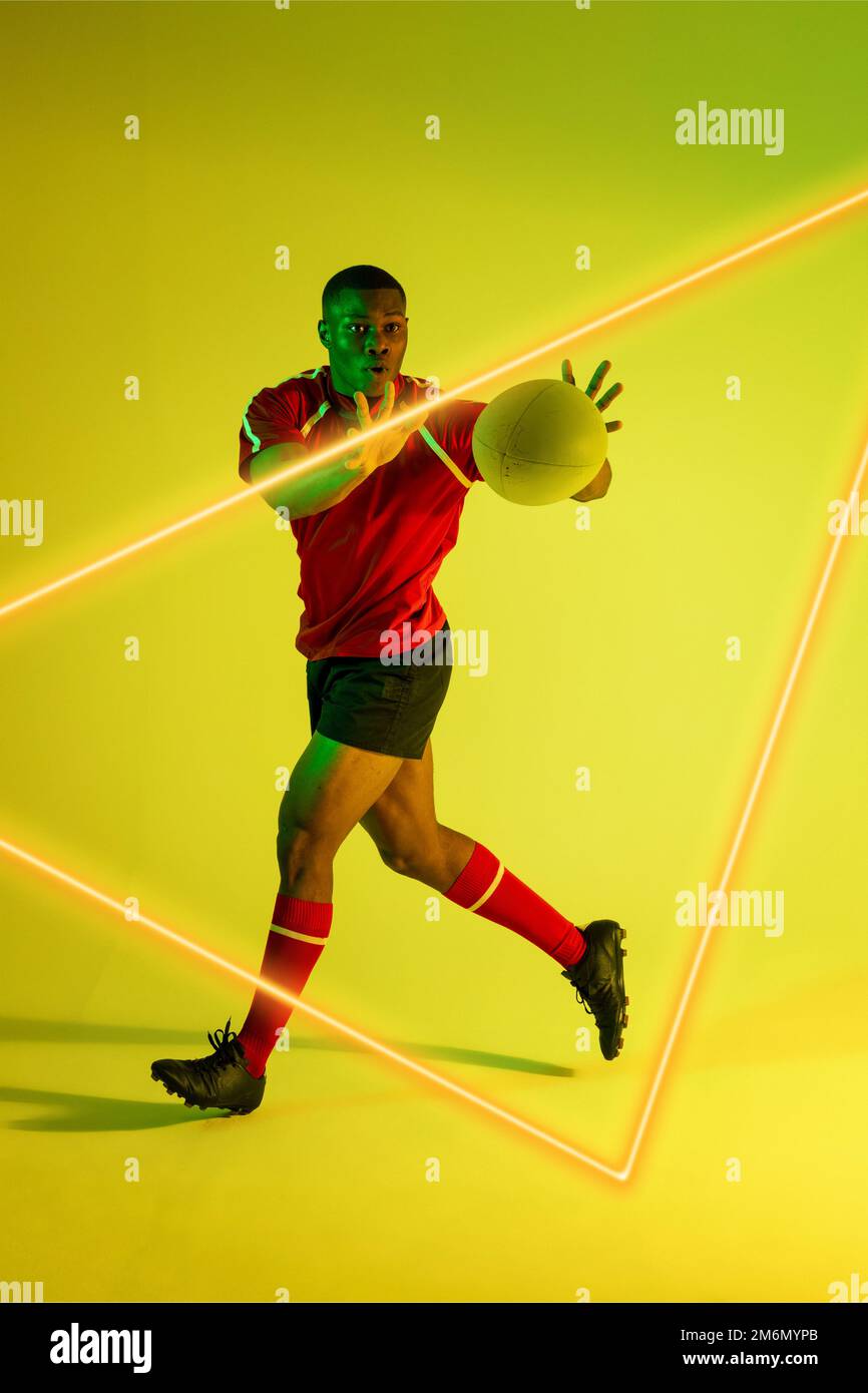African american male player throwing rugby ball by illuminated ...