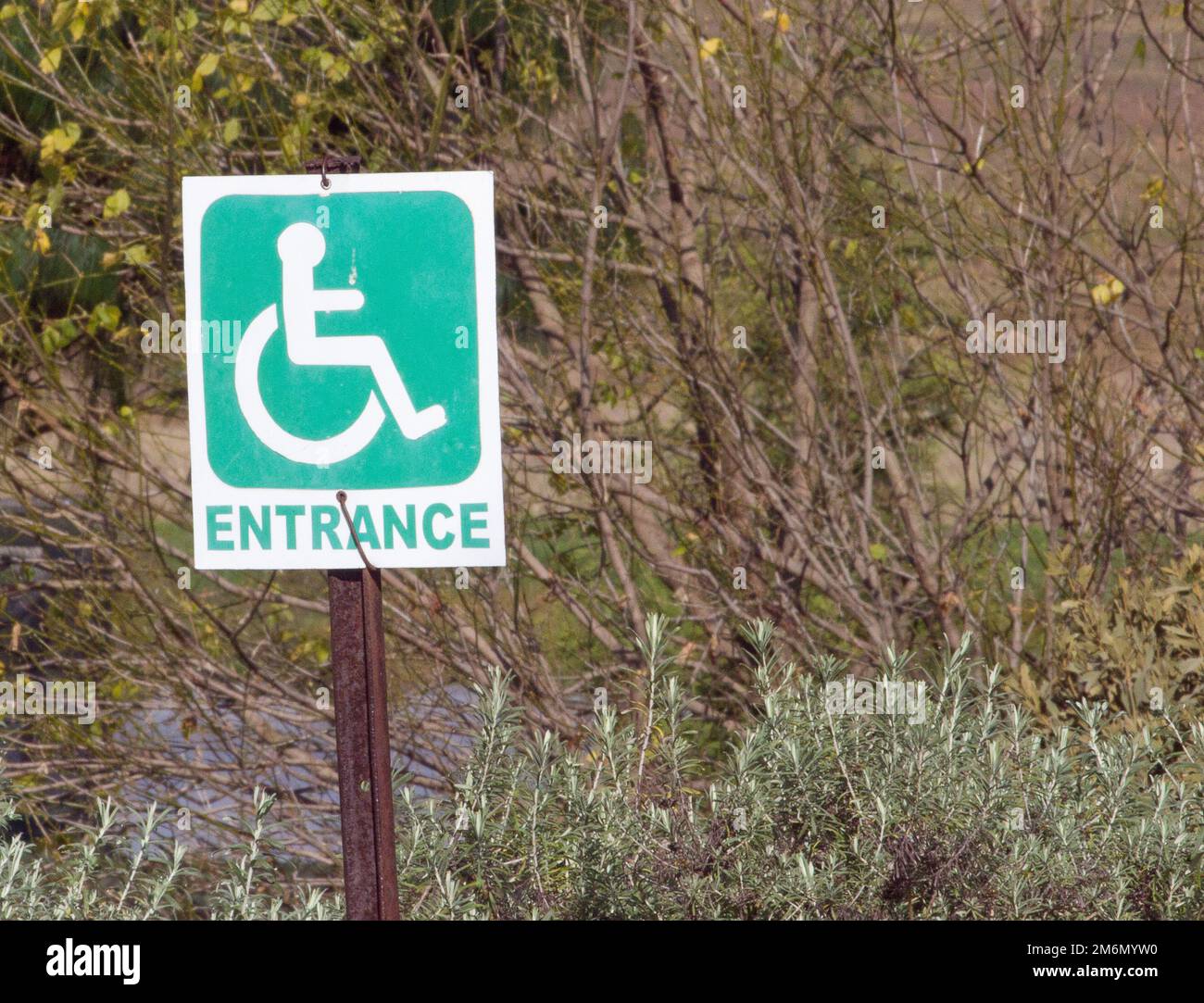 Weathered sign showing entrance for disabled persons on a wheelchair ...