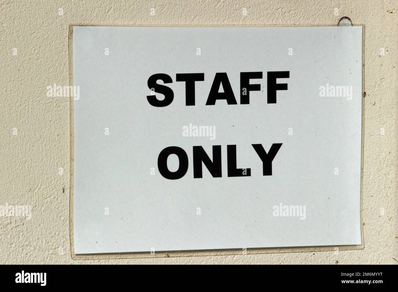 staff only words in black paint on white background against beige wall ...