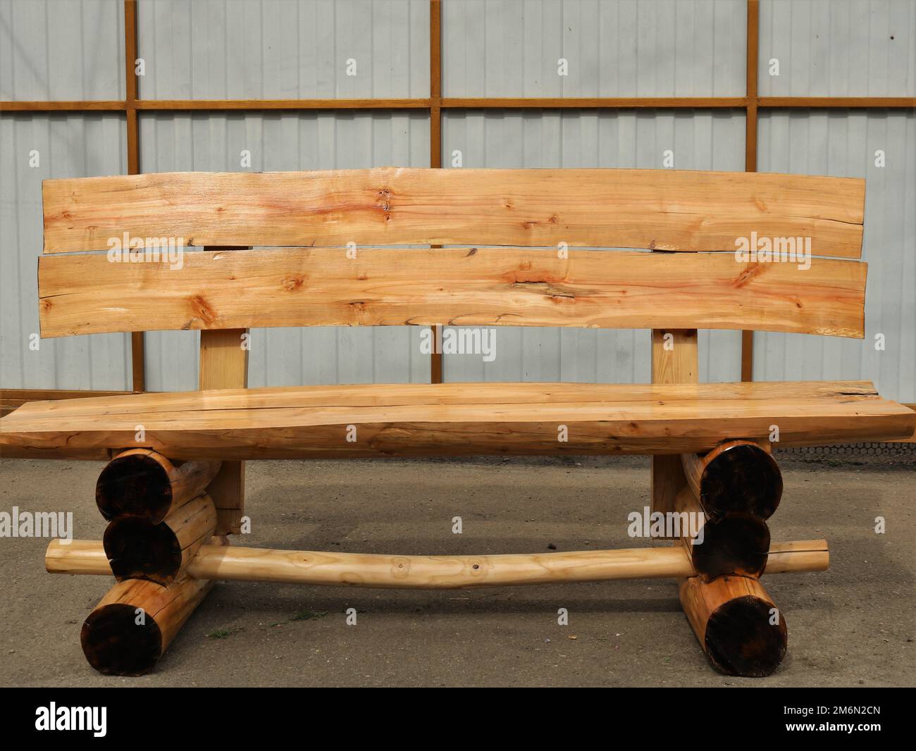 new wooden bench made of solid logs and textured boards covered with ...