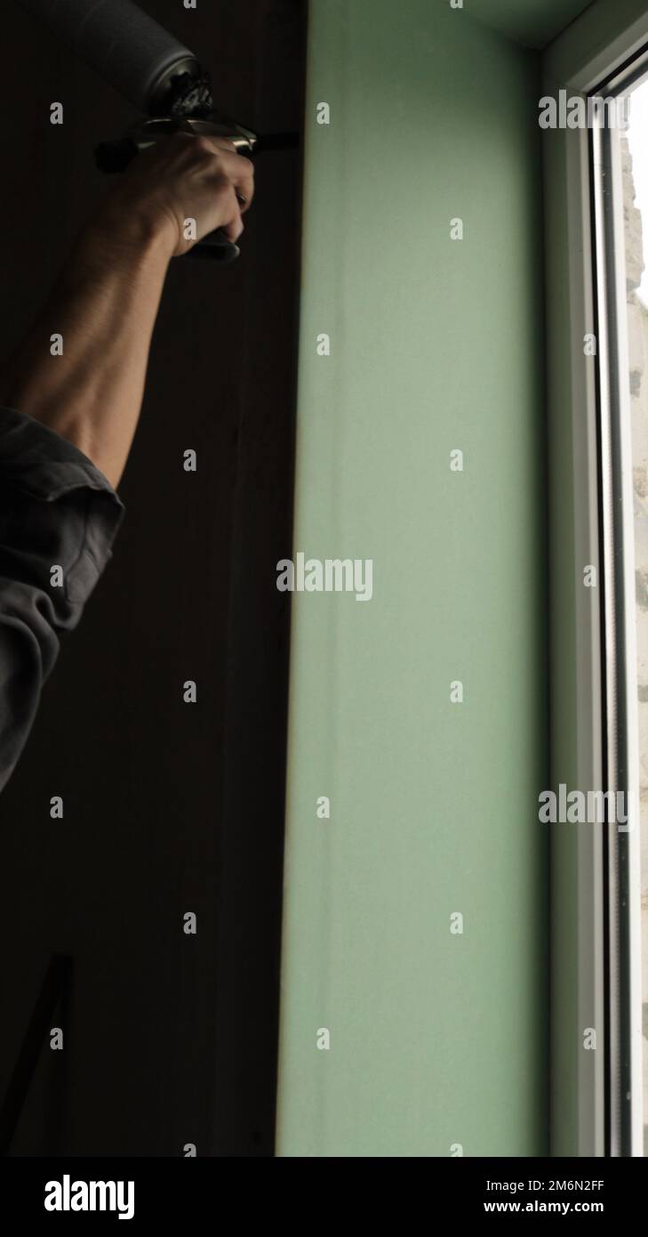 fixing chipboard sheets on the window slope with mounting foam, using a ...