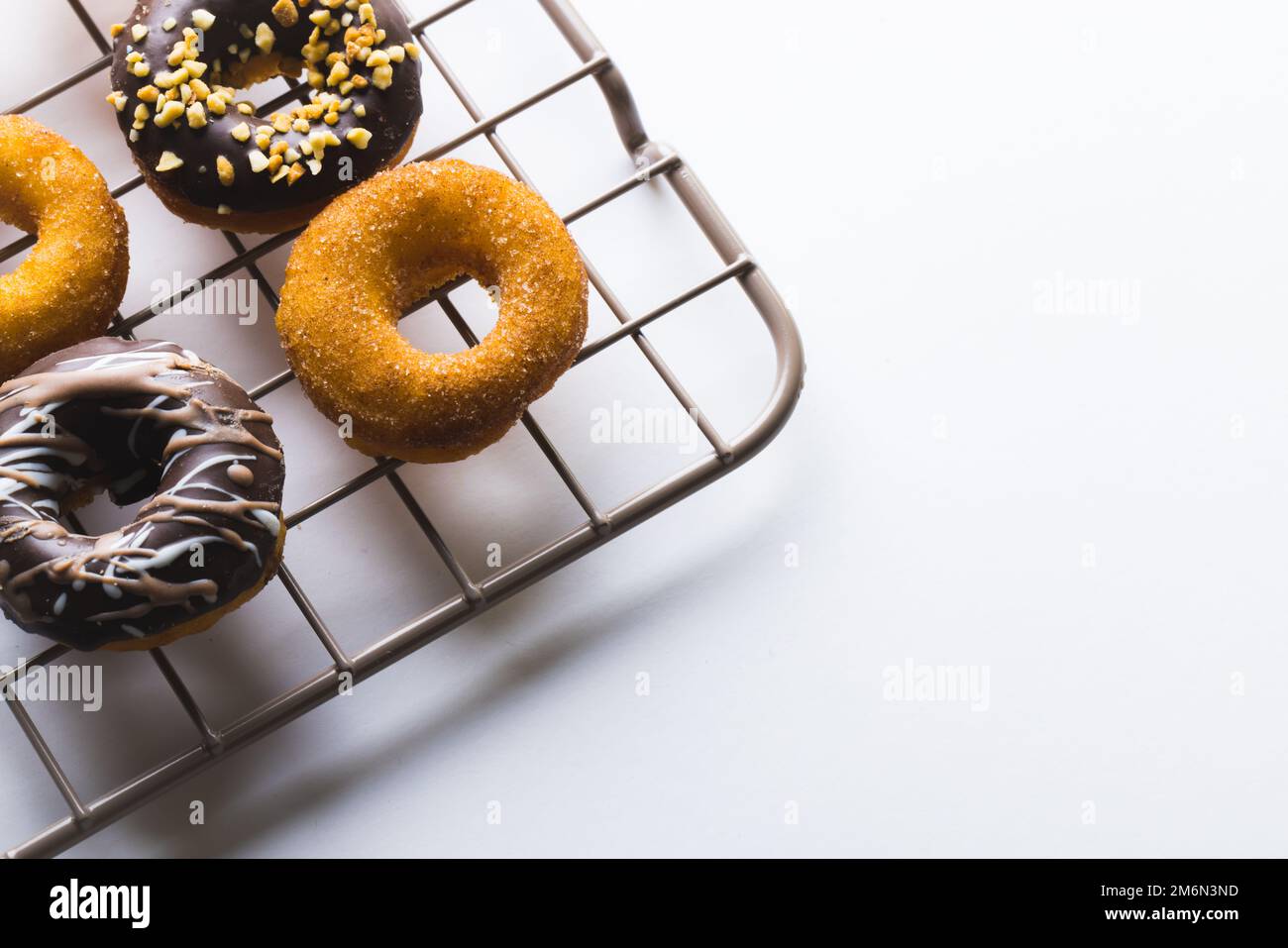 High angle view of fresh donuts on cooling rack by copy space against ...