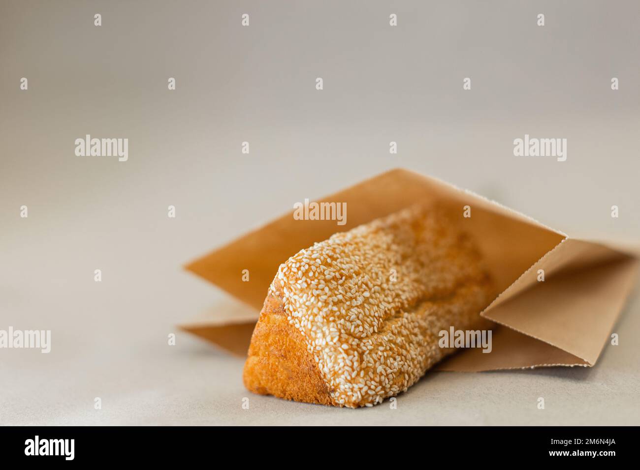 white bread with sesame seeds in a package on the background, a place ...